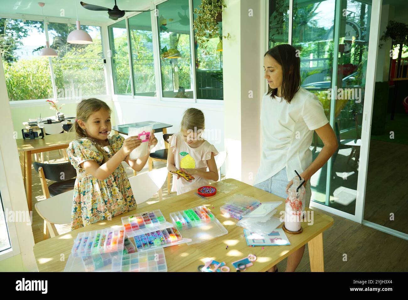 Teacher in workshop teched two girls how to assemble a thermo mosaic ...
