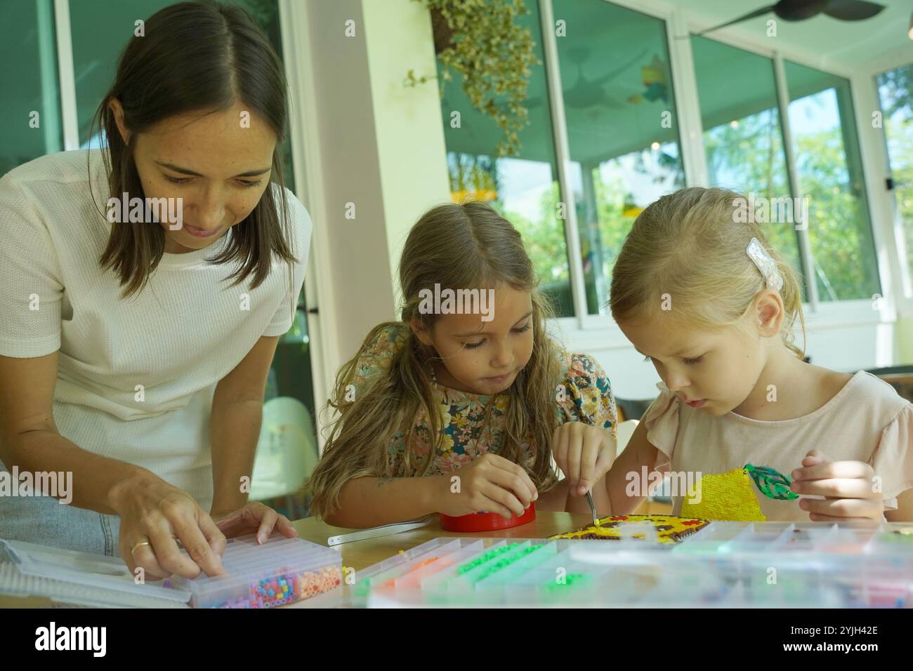 Teacher in workshop teched two girls how to assemble a thermo mosaic ...