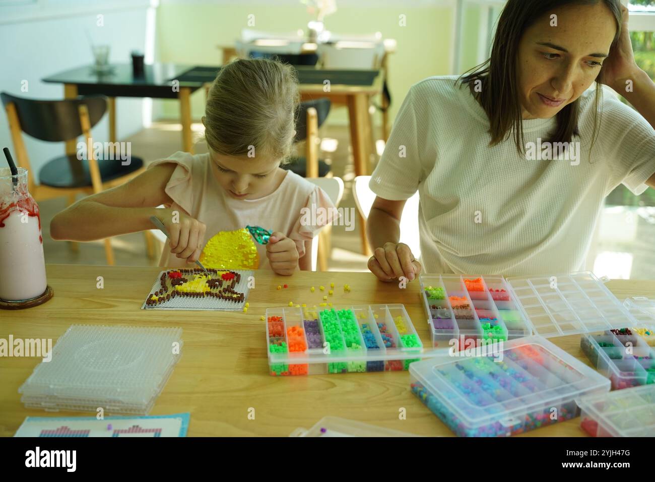 Teacher in workshop teched two girls how to assemble a thermo mosaic ...
