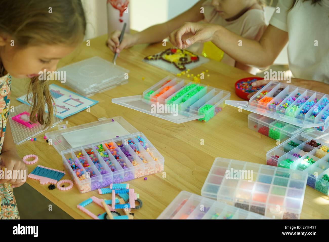 Teacher in workshop teched two girls how to assemble a thermo mosaic ...