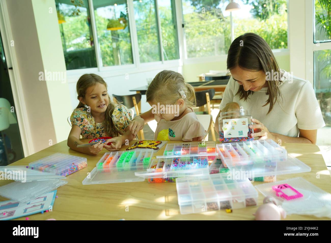 Teacher in workshop teched two girls how to assemble a thermo mosaic ...