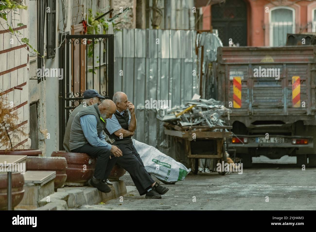 Old turkish men sitting outside the house and talking in old street of ...