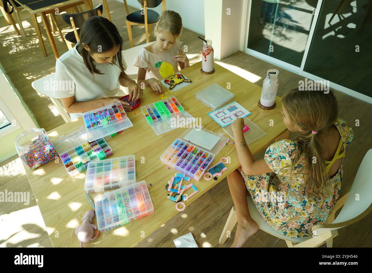 Teacher in workshop teched two girls how to assemble a thermo mosaic ...