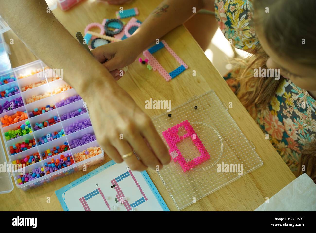 Teacher in workshop teched two girls how to assemble a thermo mosaic ...