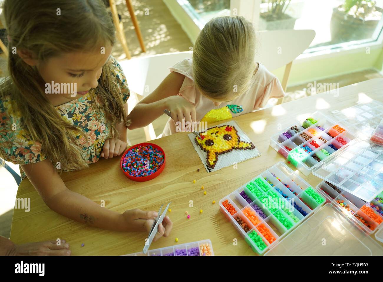 Teacher in workshop teched two girls how to assemble a thermo mosaic ...