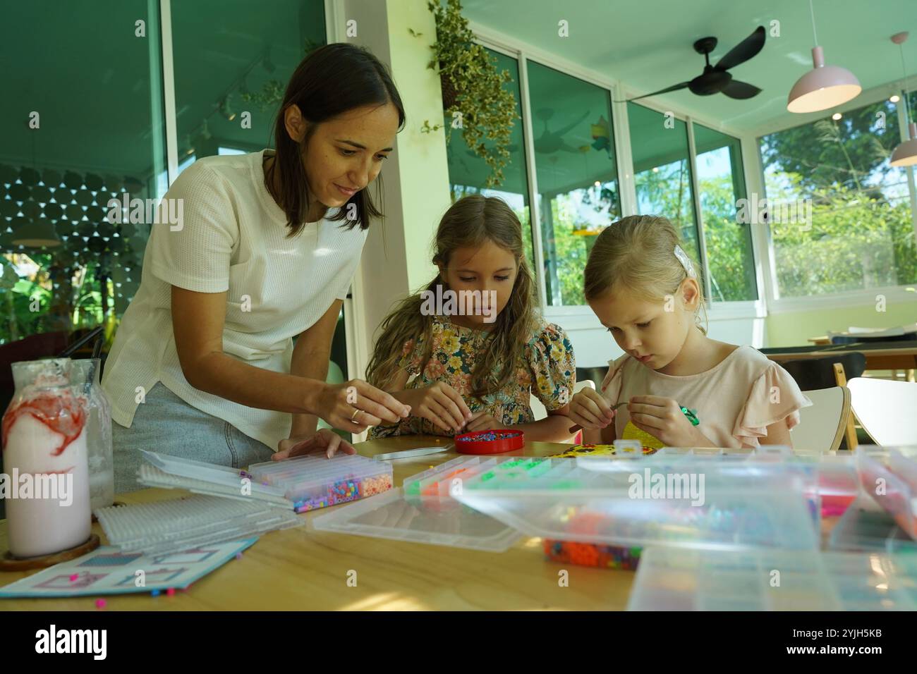 Teacher in workshop teched two girls how to assemble a thermo mosaic ...