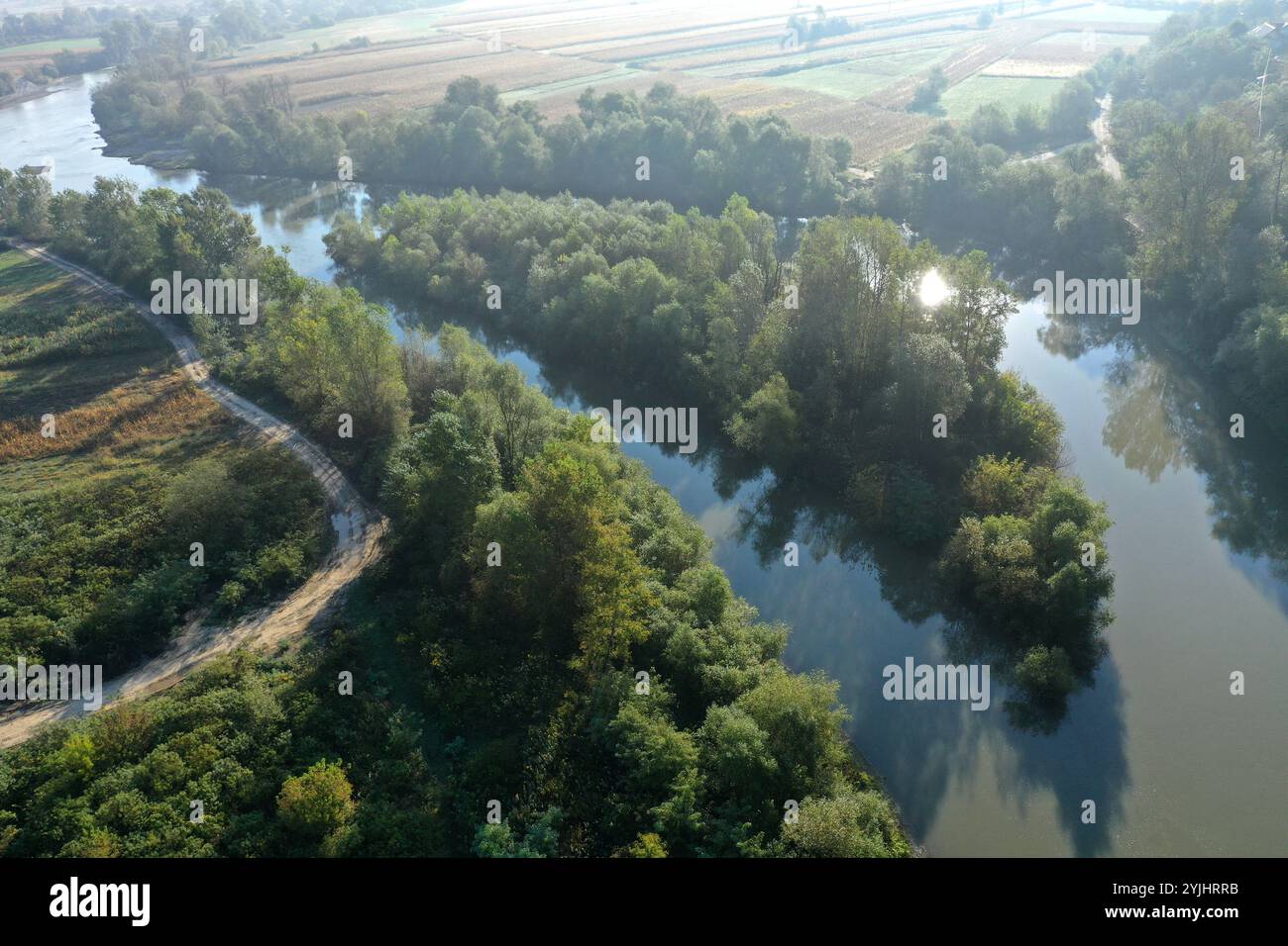 Aerial view of natural island covered with forest on a river by drone ...