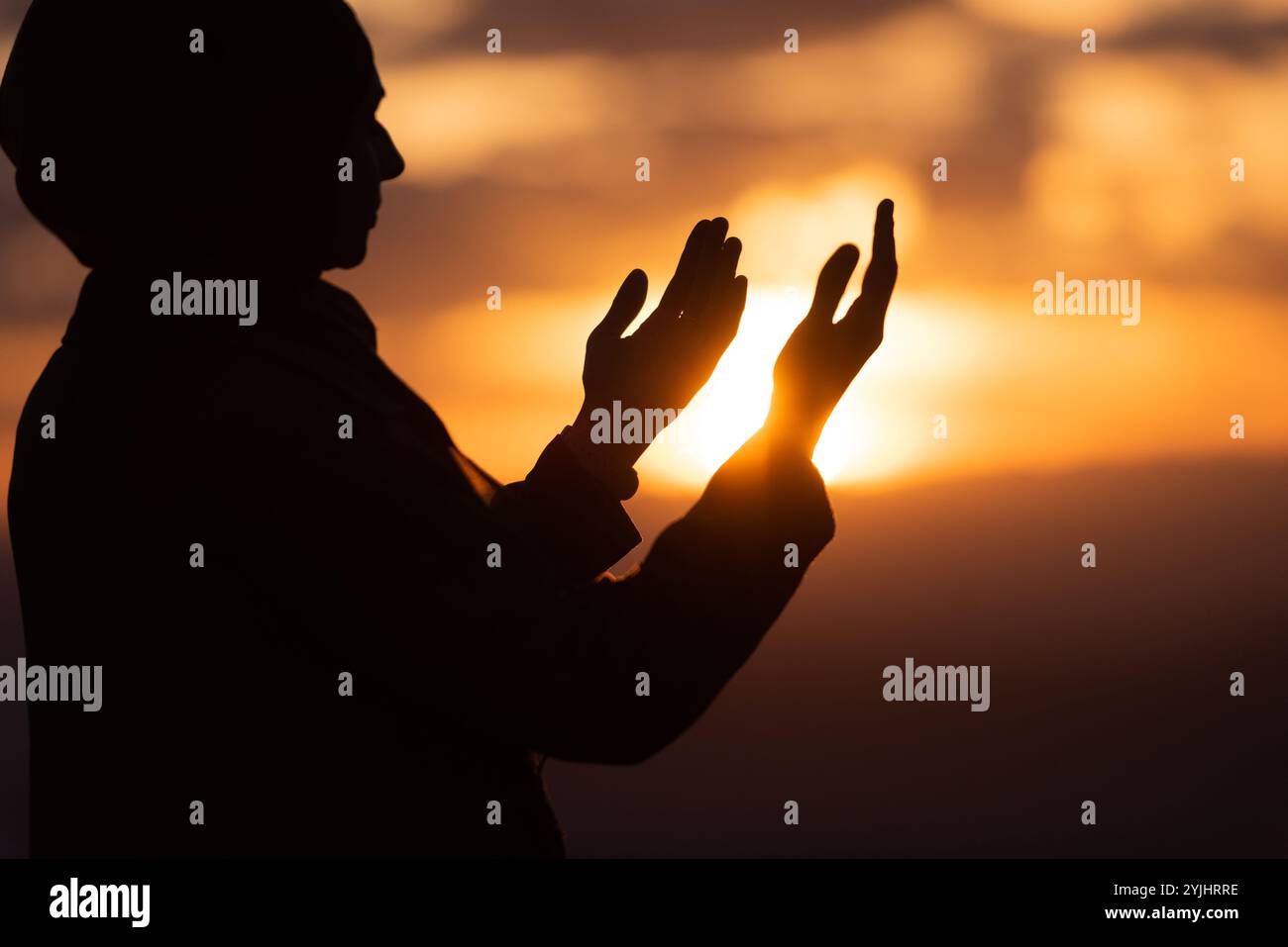 Muslim woman prayer praying with hands up open doing dua at sunset ...