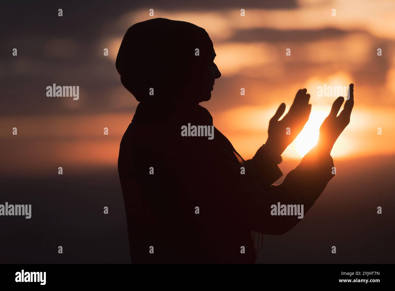 Muslim woman prayer praying with hands up open doing dua at sunset ...