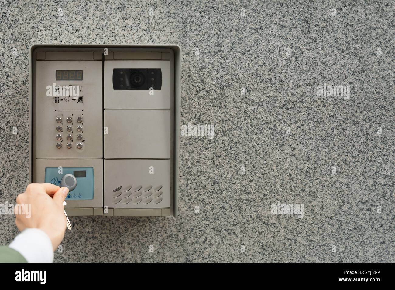 Woman's hand with fob next to intercom Stock Photo - Alamy