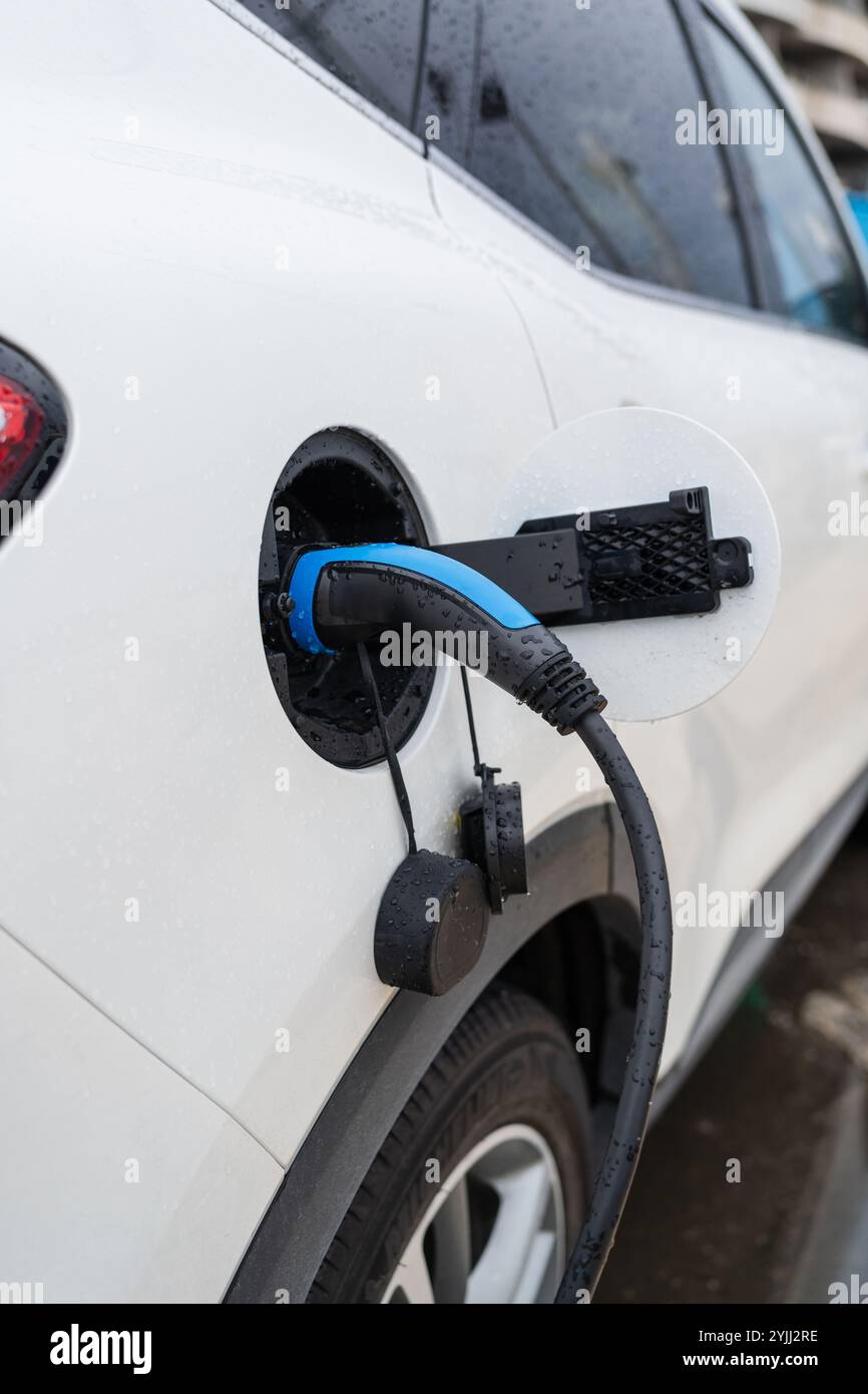 White electrical car with a charging plug Stock Photo - Alamy