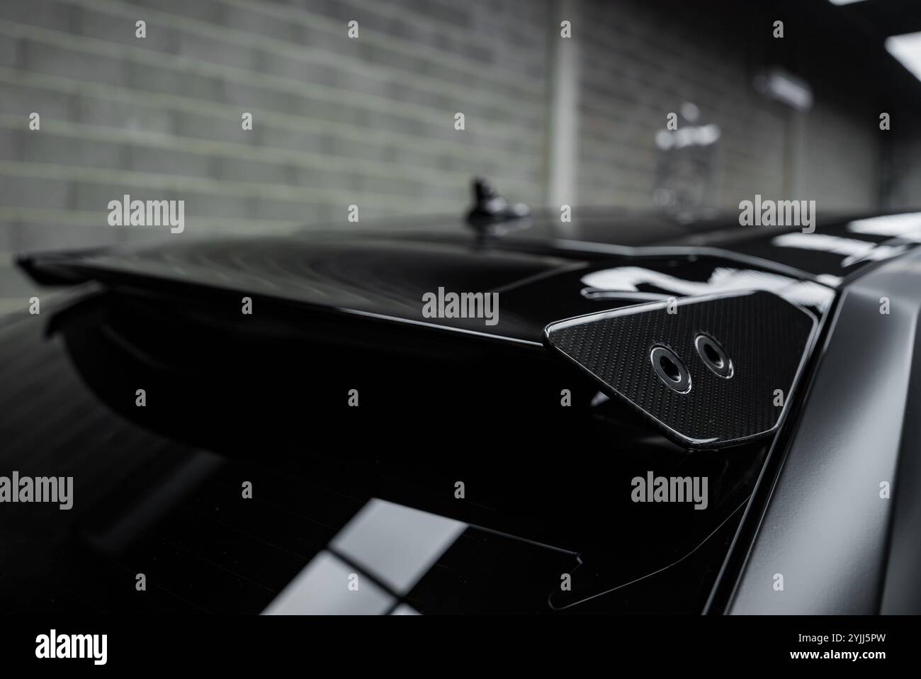 A close up view of a sleek black spoiler on a luxury supercar, possibly ...