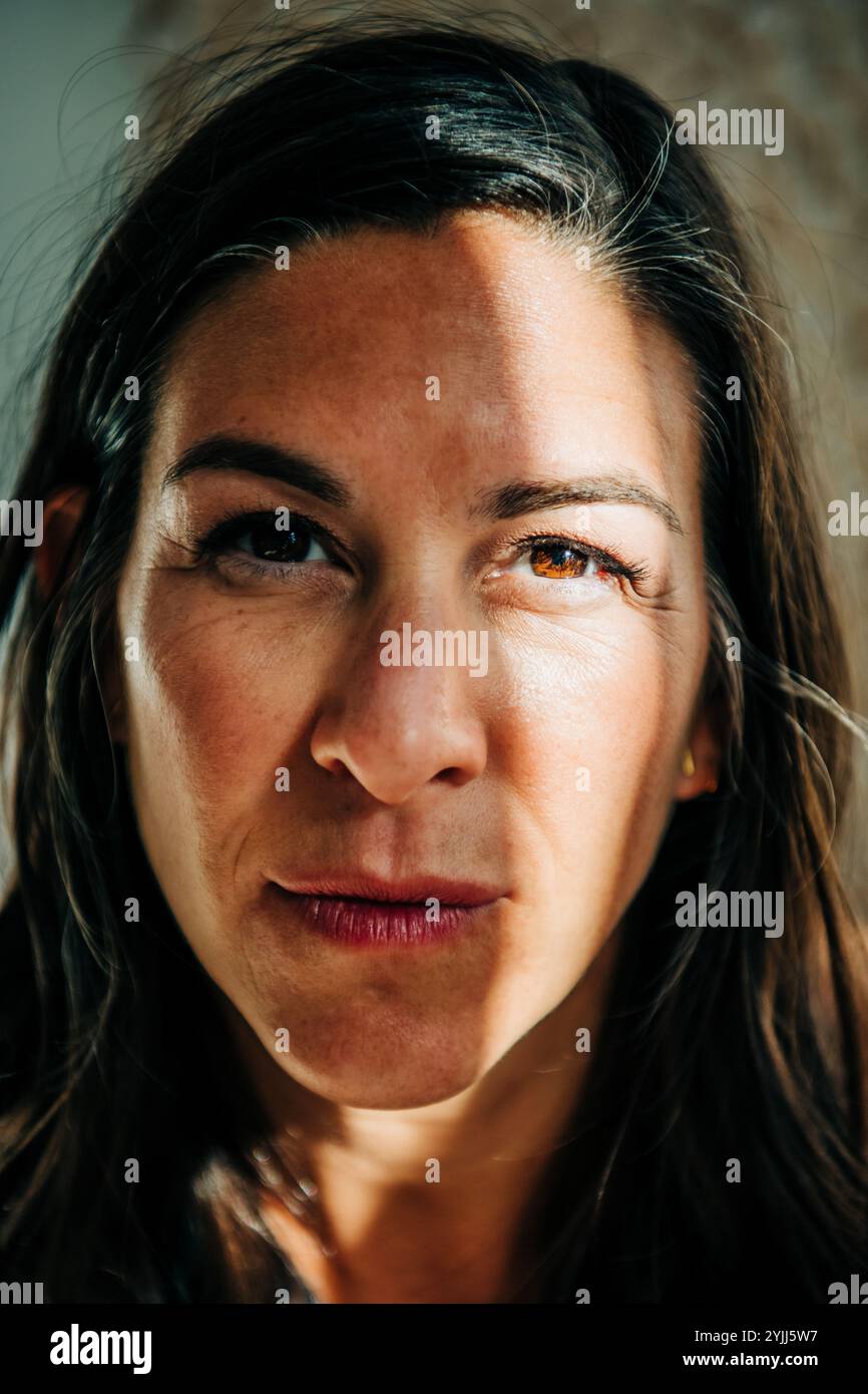 Close-up of woman’s face with dramatic sunlight and shadows Stock Photo ...