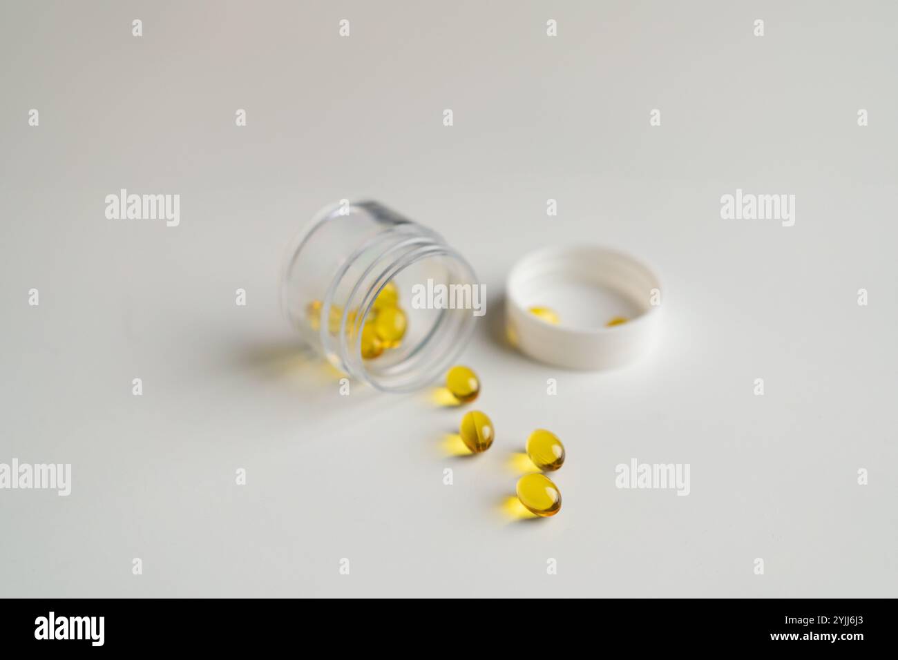 Open pill bottle with capsules on white background Stock Photo - Alamy
