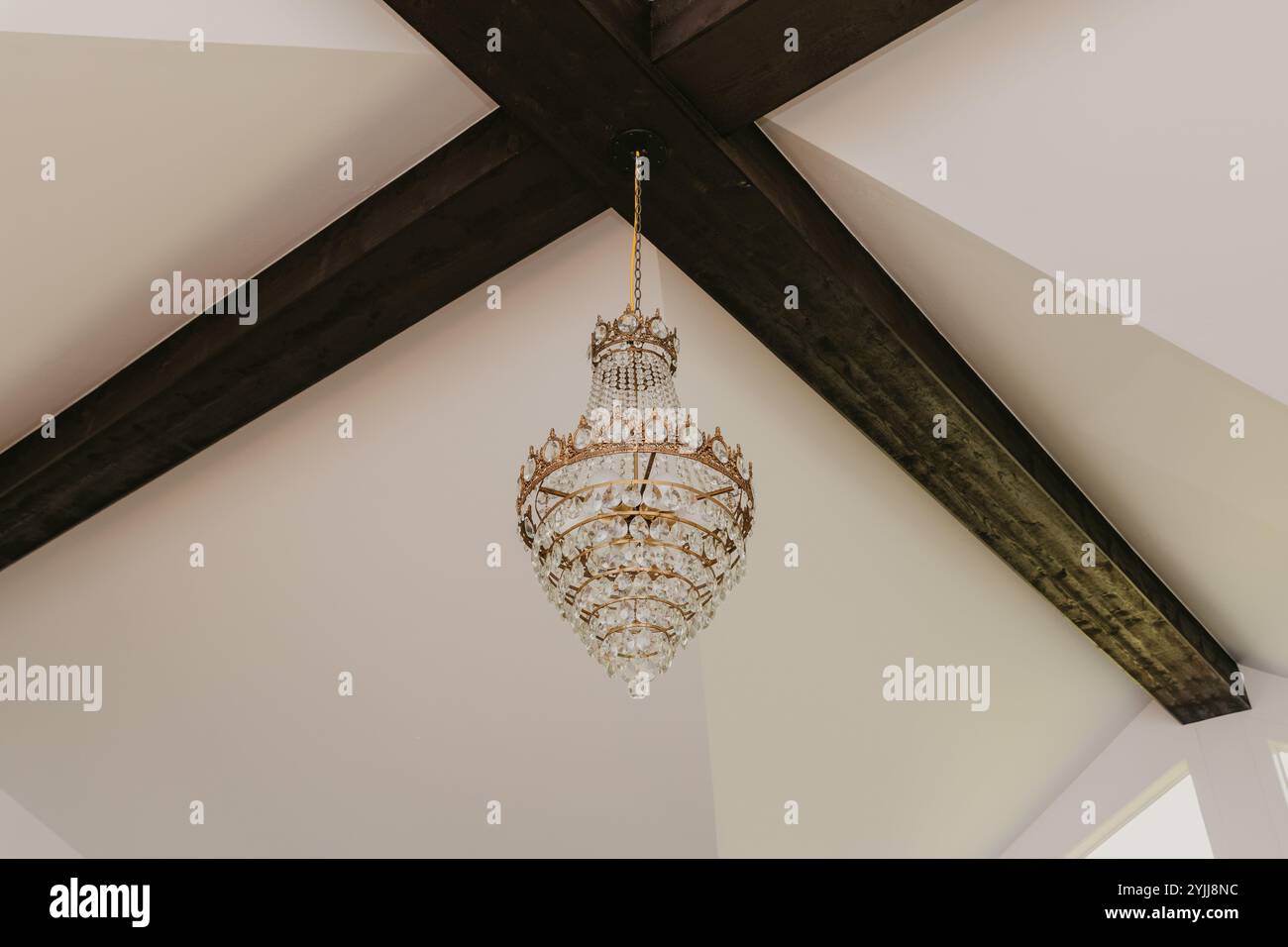 Golden Crystal Chandelier hanging in a rustic room Stock Photo - Alamy