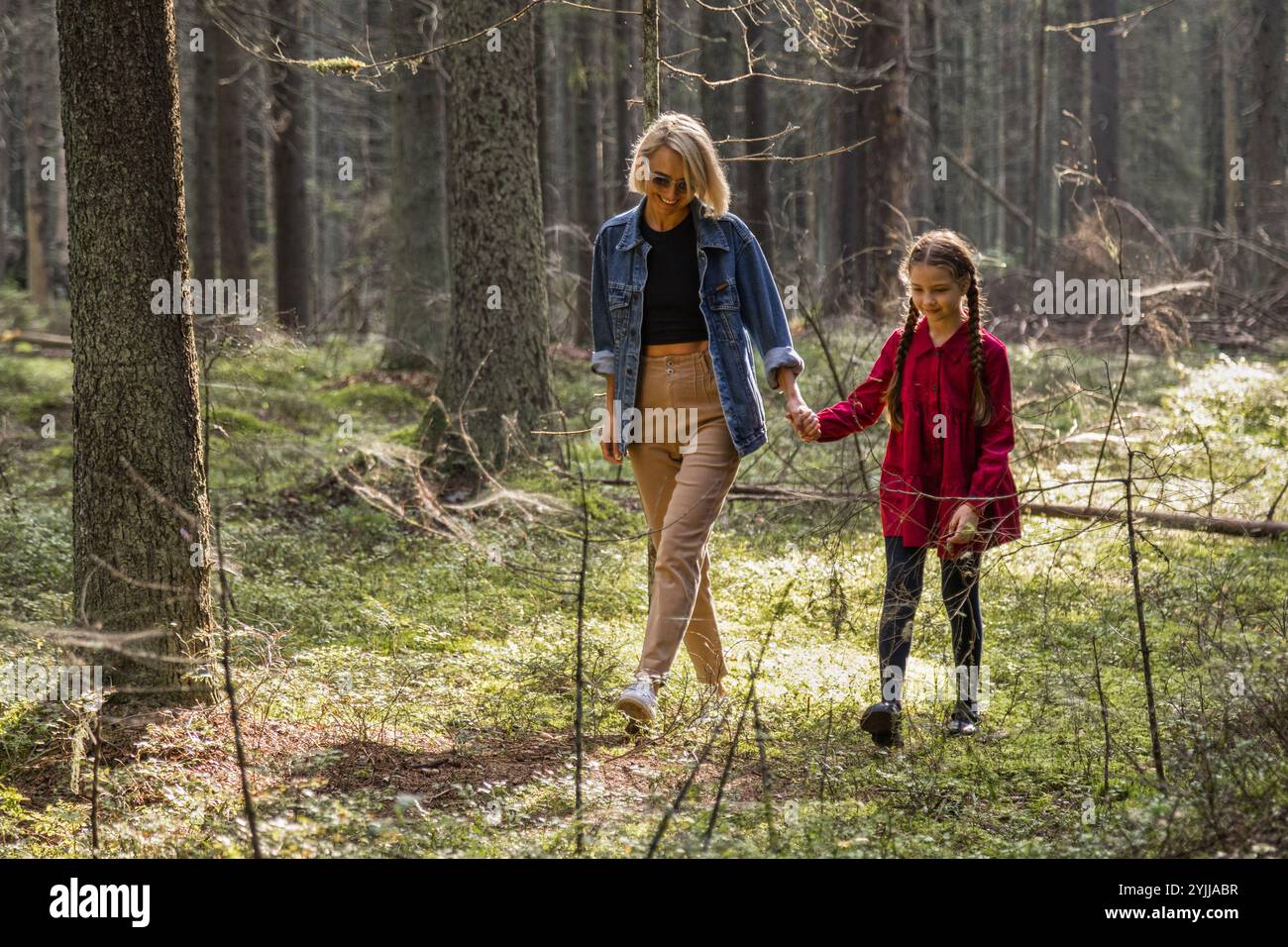 Mother and daughter walking together on woodland trail Stock Photo - Alamy