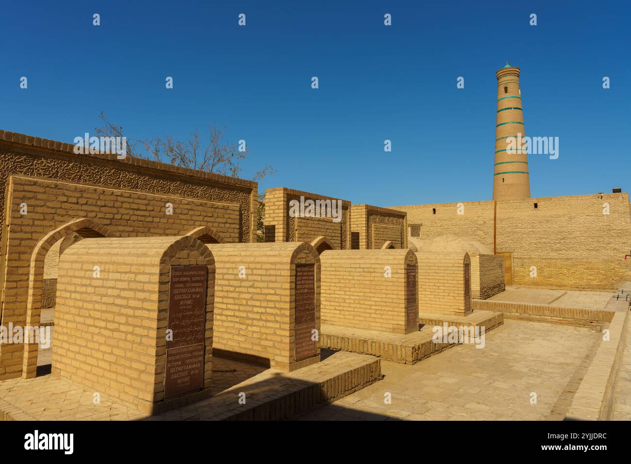 A row of tombs with a tall tower in the background Stock Photo - Alamy