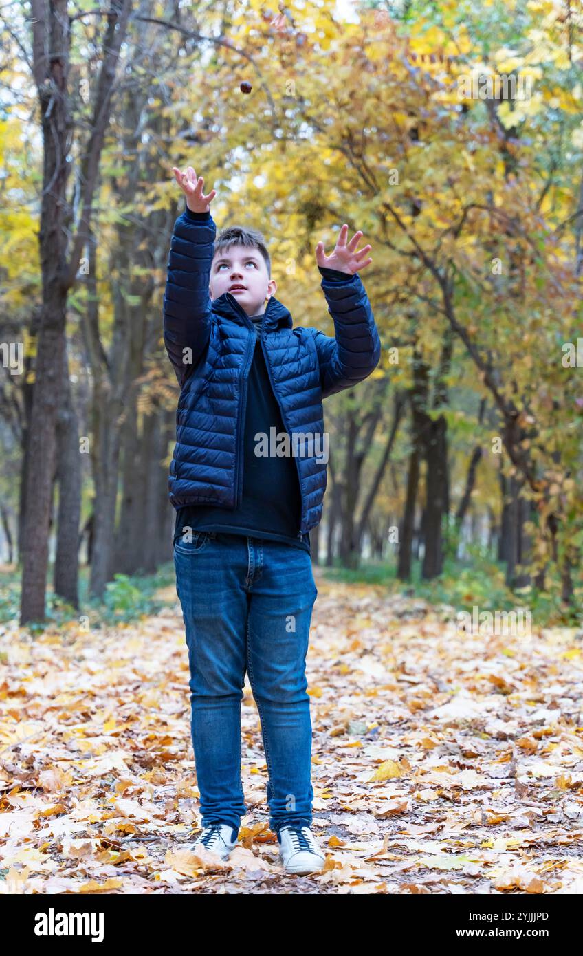 A 12-year-old white boy in a blue jacket and blue jeans is playing with ...