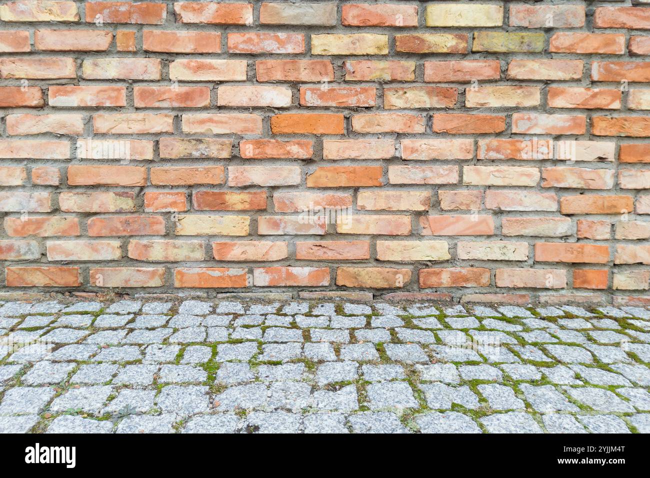 Red brick wall with cobblestone pavement base Stock Photo - Alamy