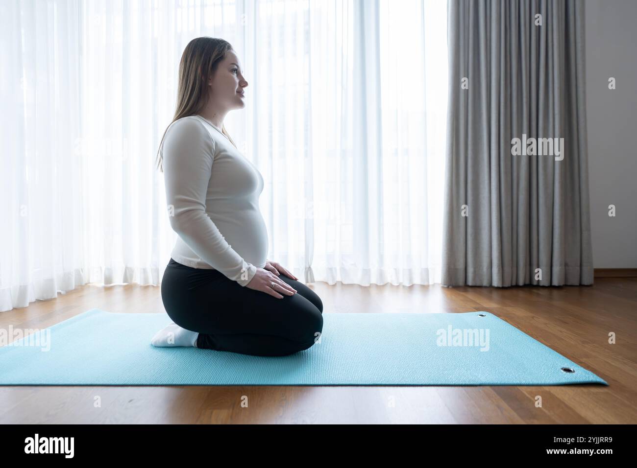 Gen Z pregnant woman sitting on yoga mat at home. Workout, yoga and ...