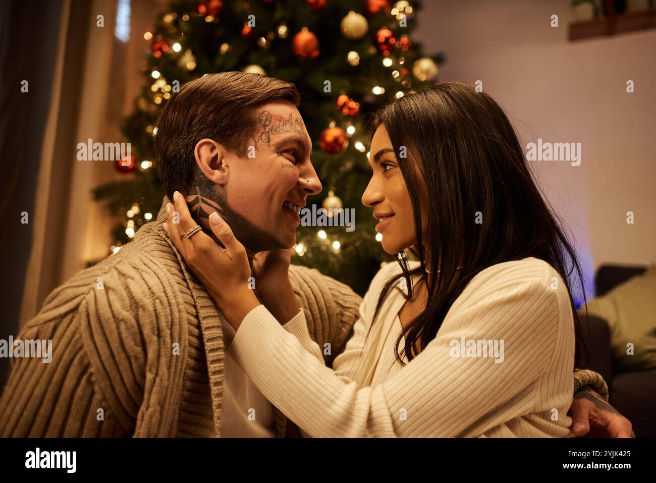 A loving couple shares a tender moment at home surrounded by Christmas ...