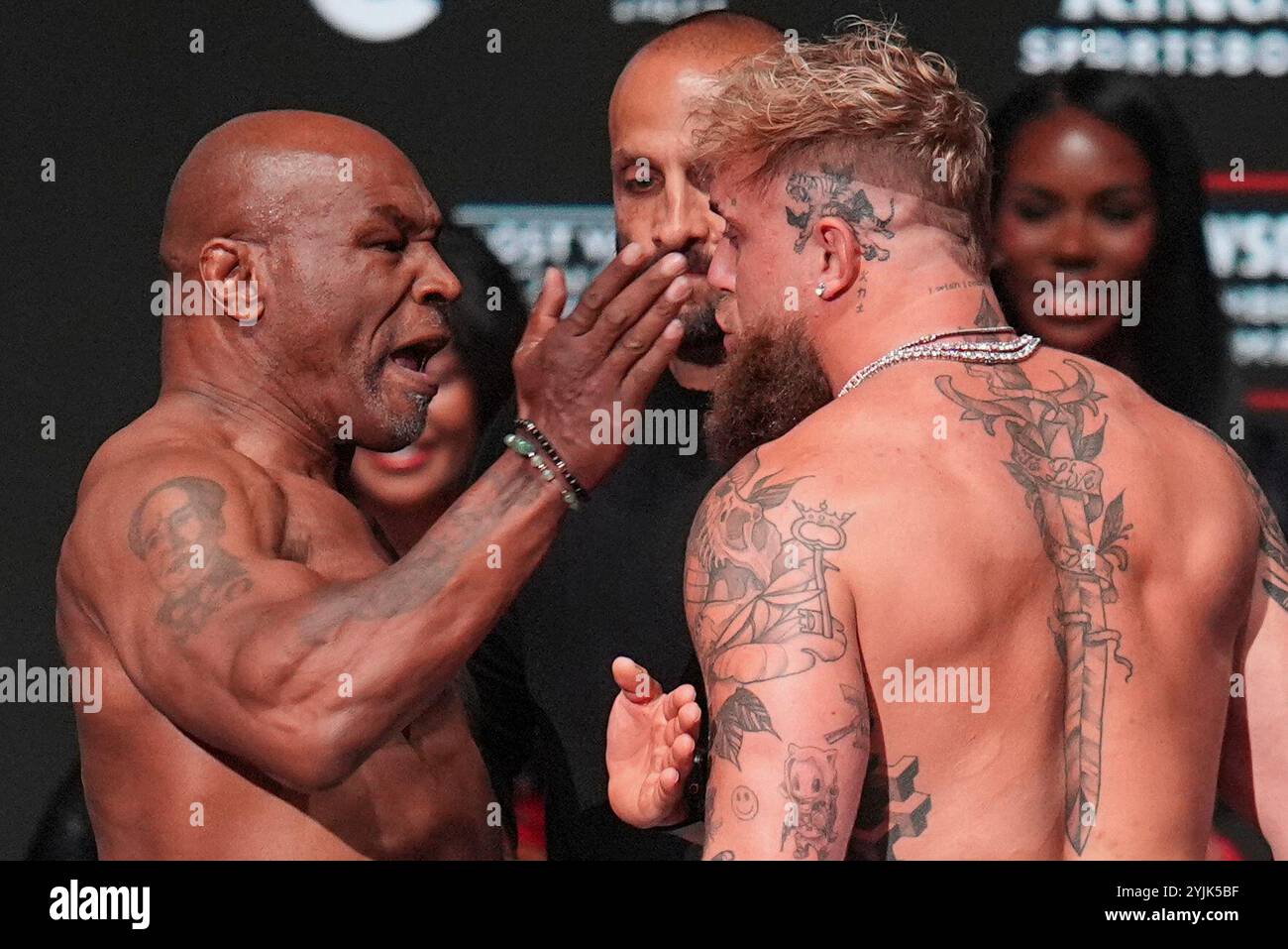Mike Tyson, left, slaps Jake Paul during the weigh-in ahead of their ...