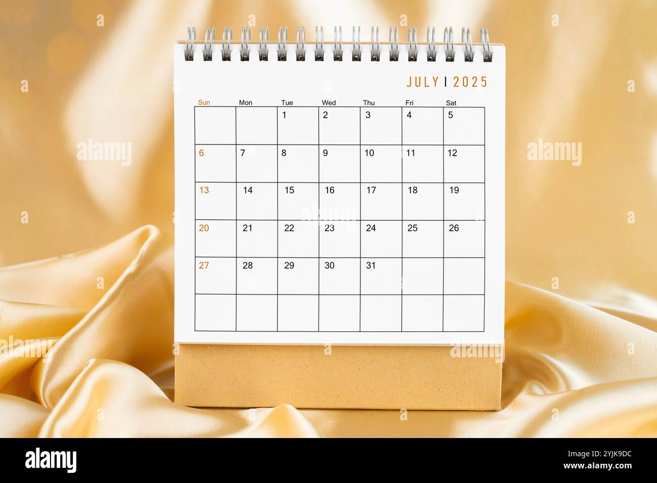 Front view of July 2025 desk calendar on gold silk background Stock ...