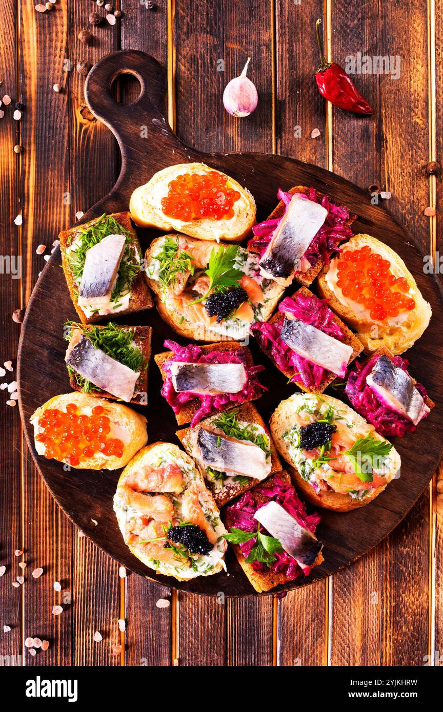 Cocktail canapes with herring, cream cheese and caviar on rye bread ...