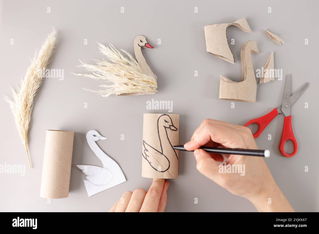 a creative craft project in progress. a hand is holding a pencil and ...