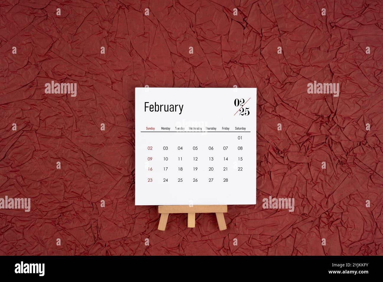 February 2025 calendar on red crumpled paper background. Directly above ...