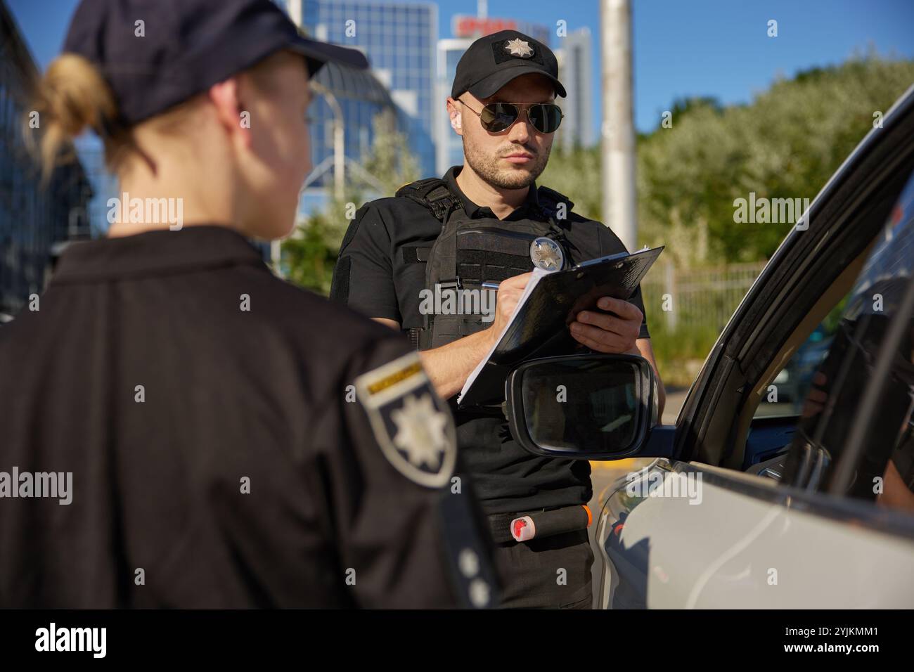 Police officers writing traffic ticket for parking violation Stock ...