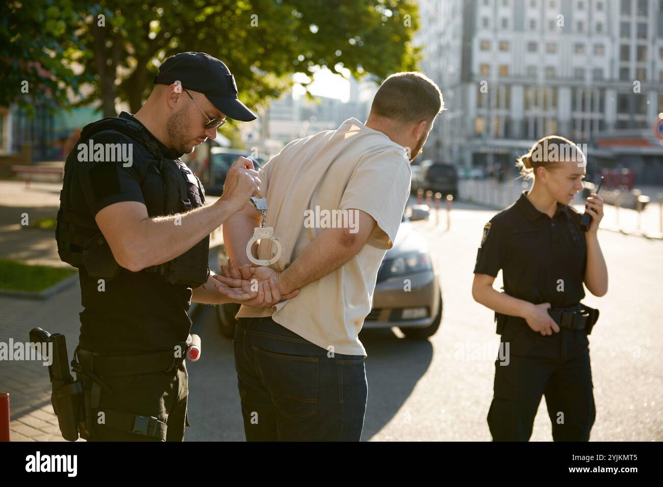 Patrol officers team arresting male offender on city street Stock Photo ...
