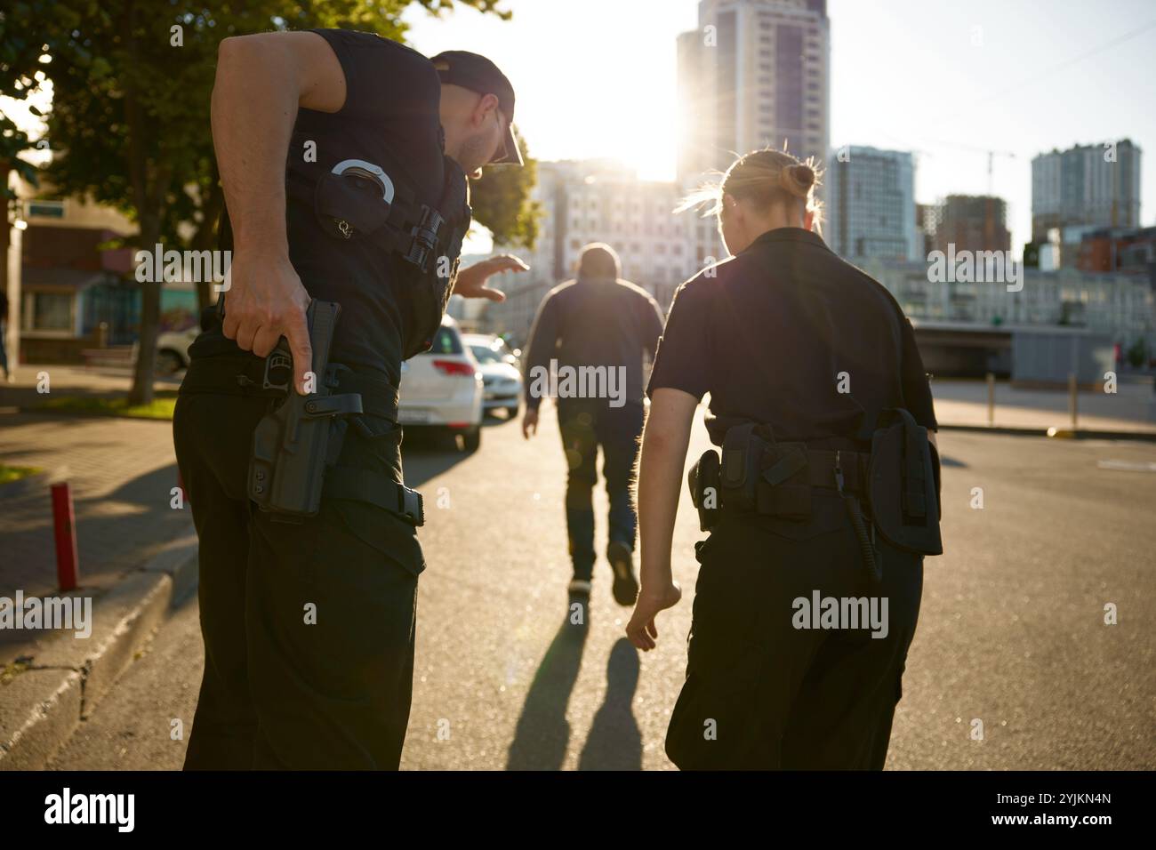 Patrol officers preparing weapon while chasing offender on urban street ...