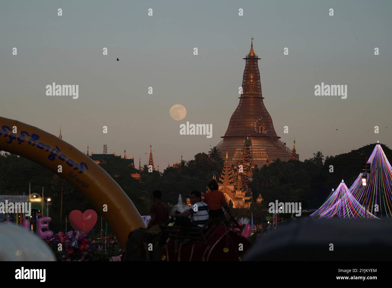 The supermoon rise near Myanmar Landmark Shwedagon while people enjoy at fun fair to mark the ...