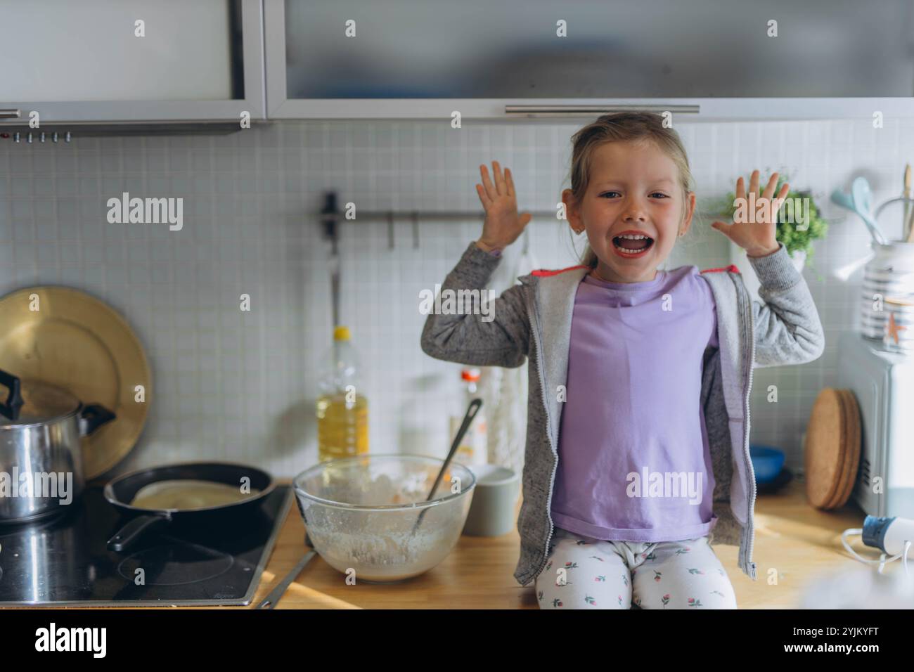 Cute little girl kid in the kitchen at home making pancakes. Children ...
