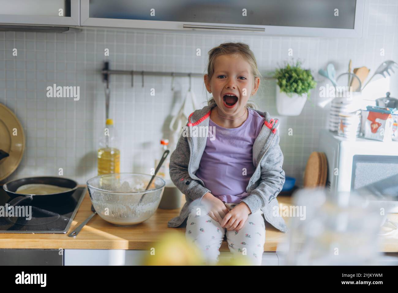 Cute little girl kid in the kitchen at home making pancakes. Children ...