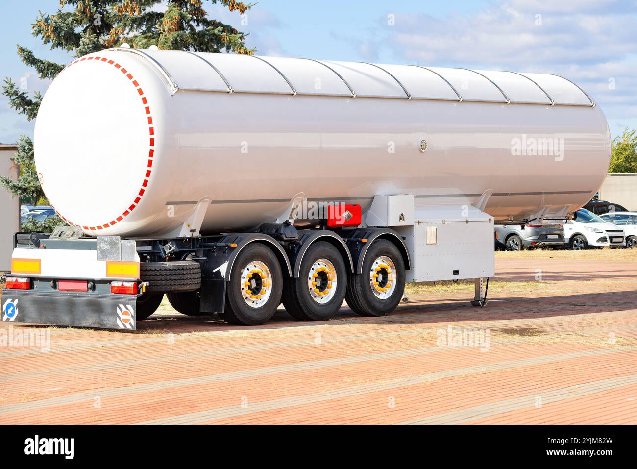A striking white fuel tanker parked under a clear blue sky in an ...