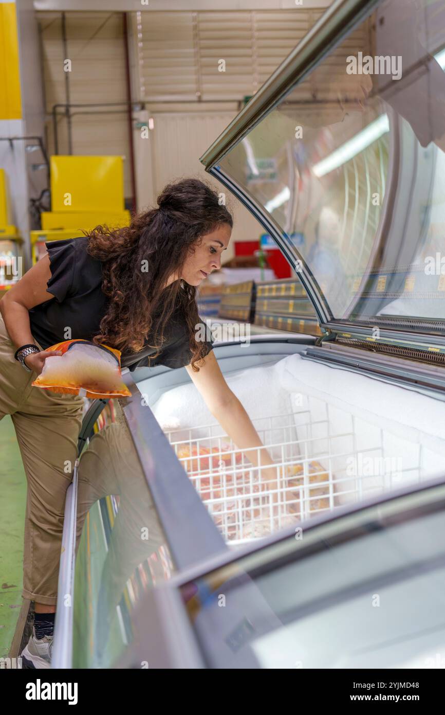 Middle-Aged Woman Selecting Frozen Foods in Supermarket's Freezer ...