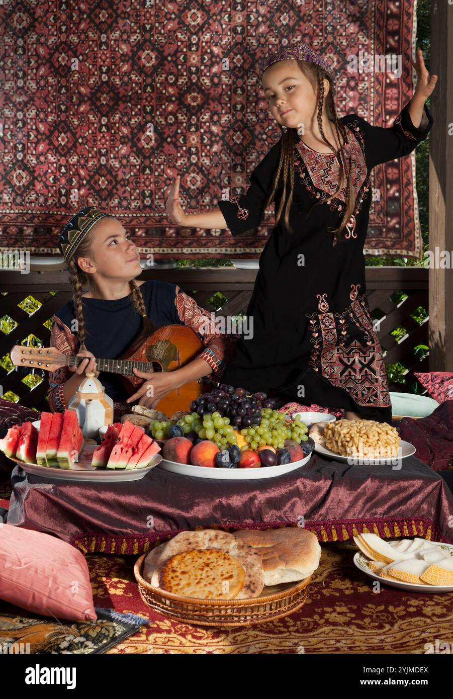 Two little girls playing mandolin and dancing at the table Stock Photo ...