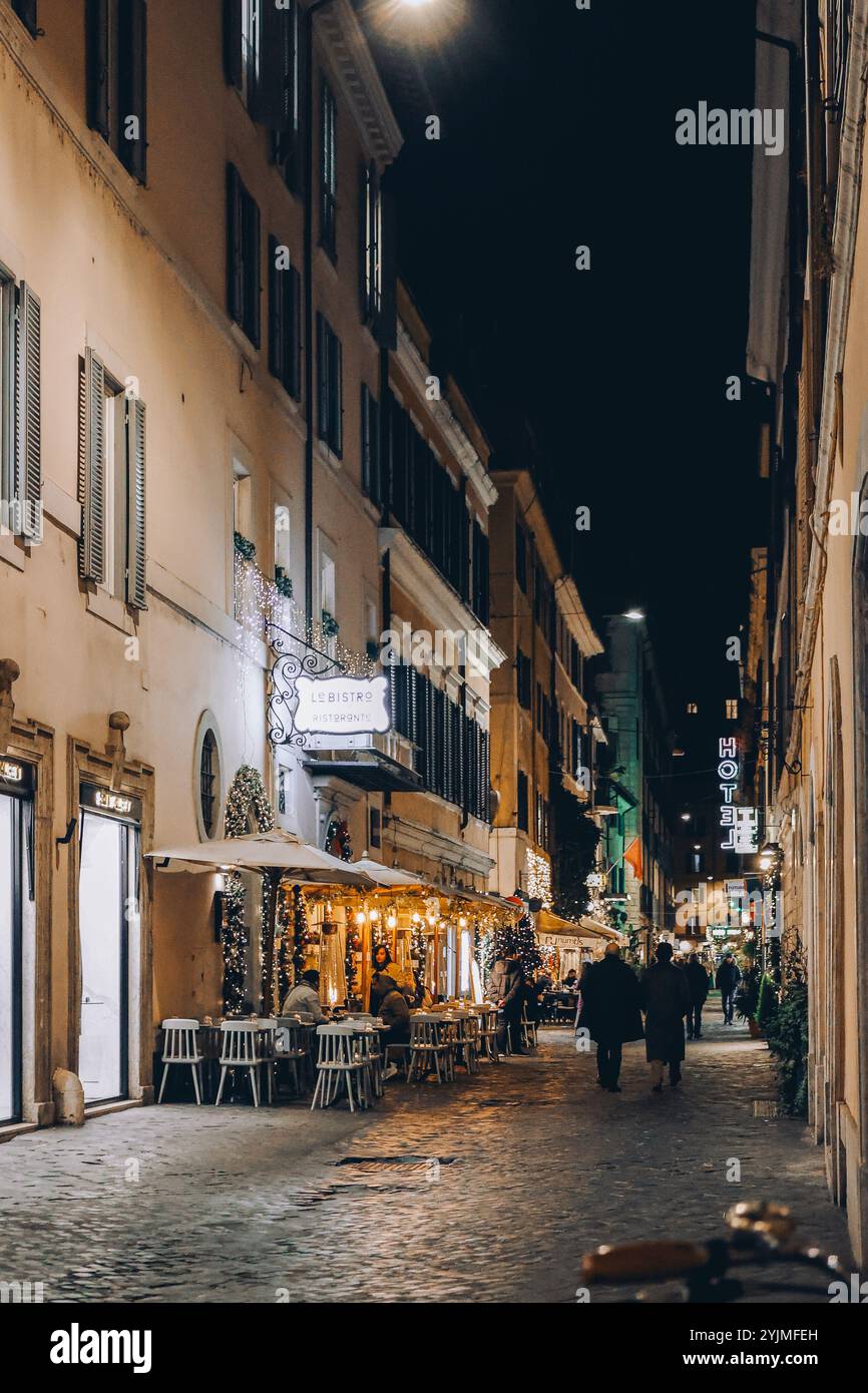 Rome, Italy - December 4, 2023: Old cozy street Illuminated at night ...