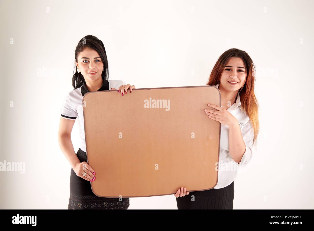 Two women carrying signboard on white background Stock Photo - Alamy