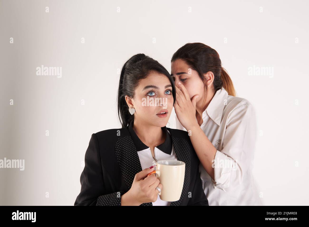 business women tell a secret: on white background Stock Photo - Alamy