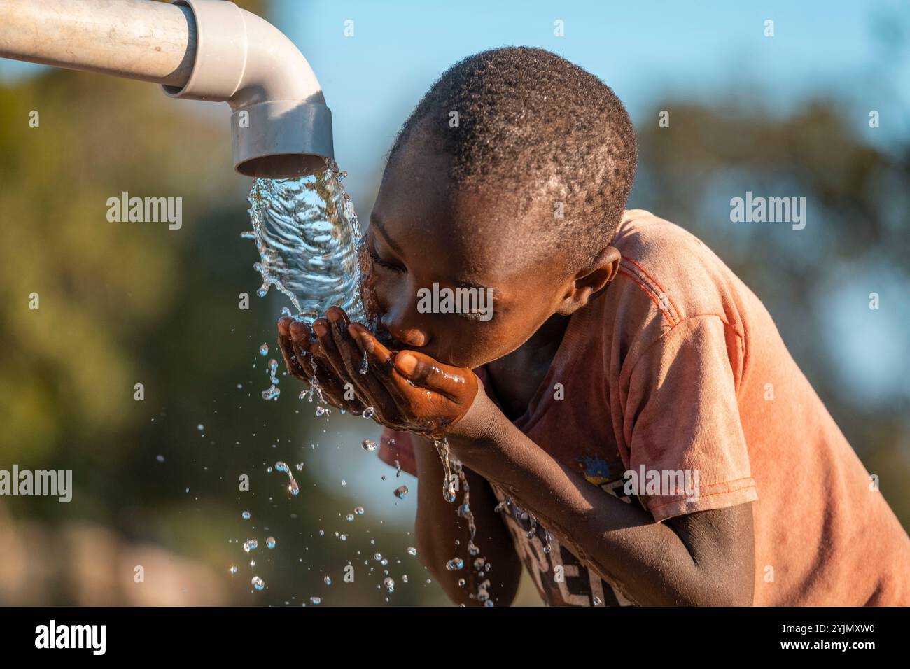Mali,Kenya - Agust 23 2021:happy boy drinking water from water pump ...