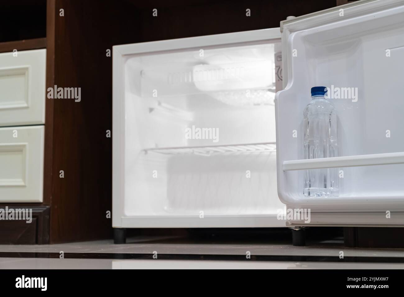 mini fridge in low angle view, inside it’s empty shelves placed under ...