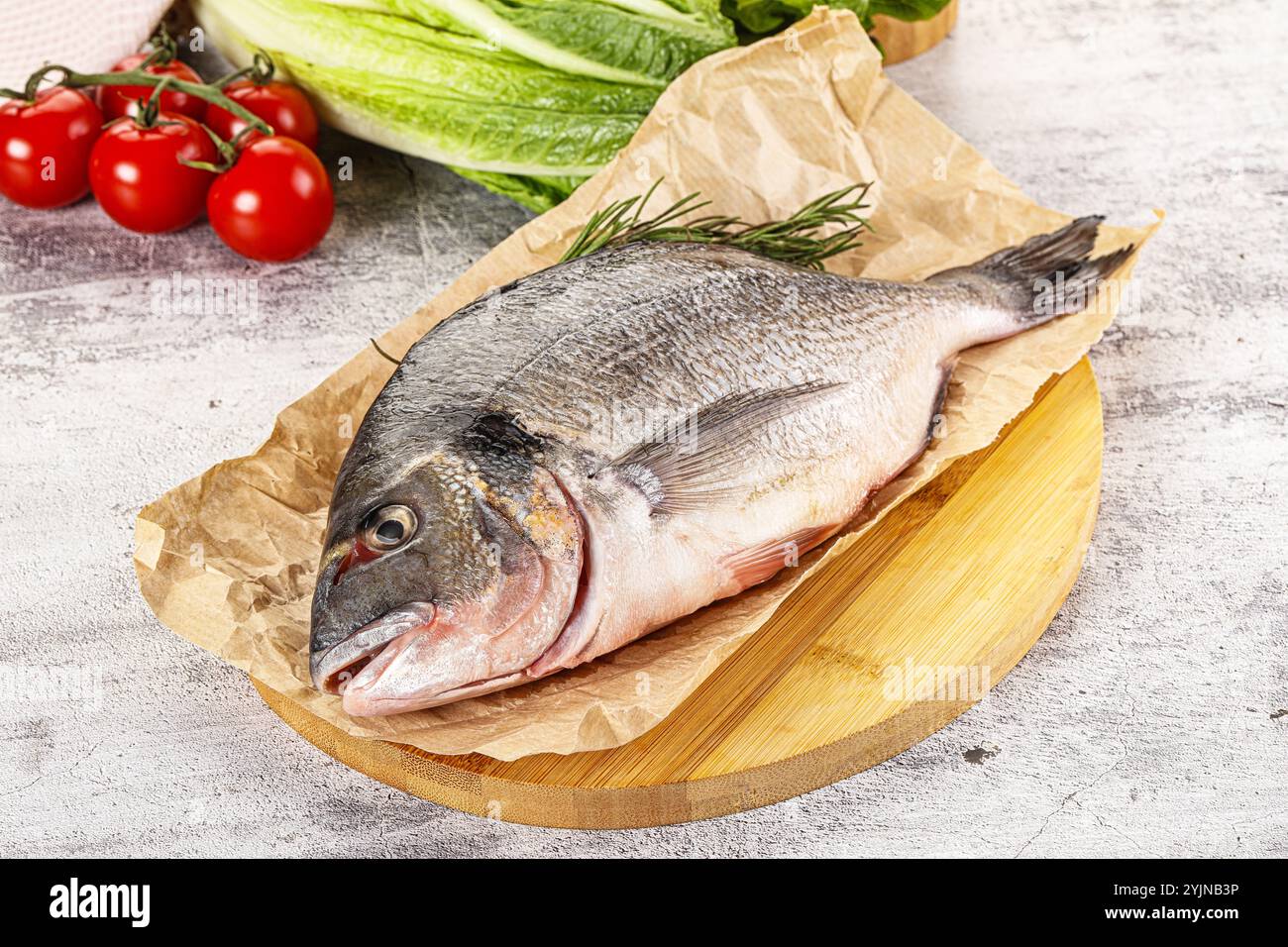 Raw dorada fish served rosemary for cooking Stock Photo - Alamy