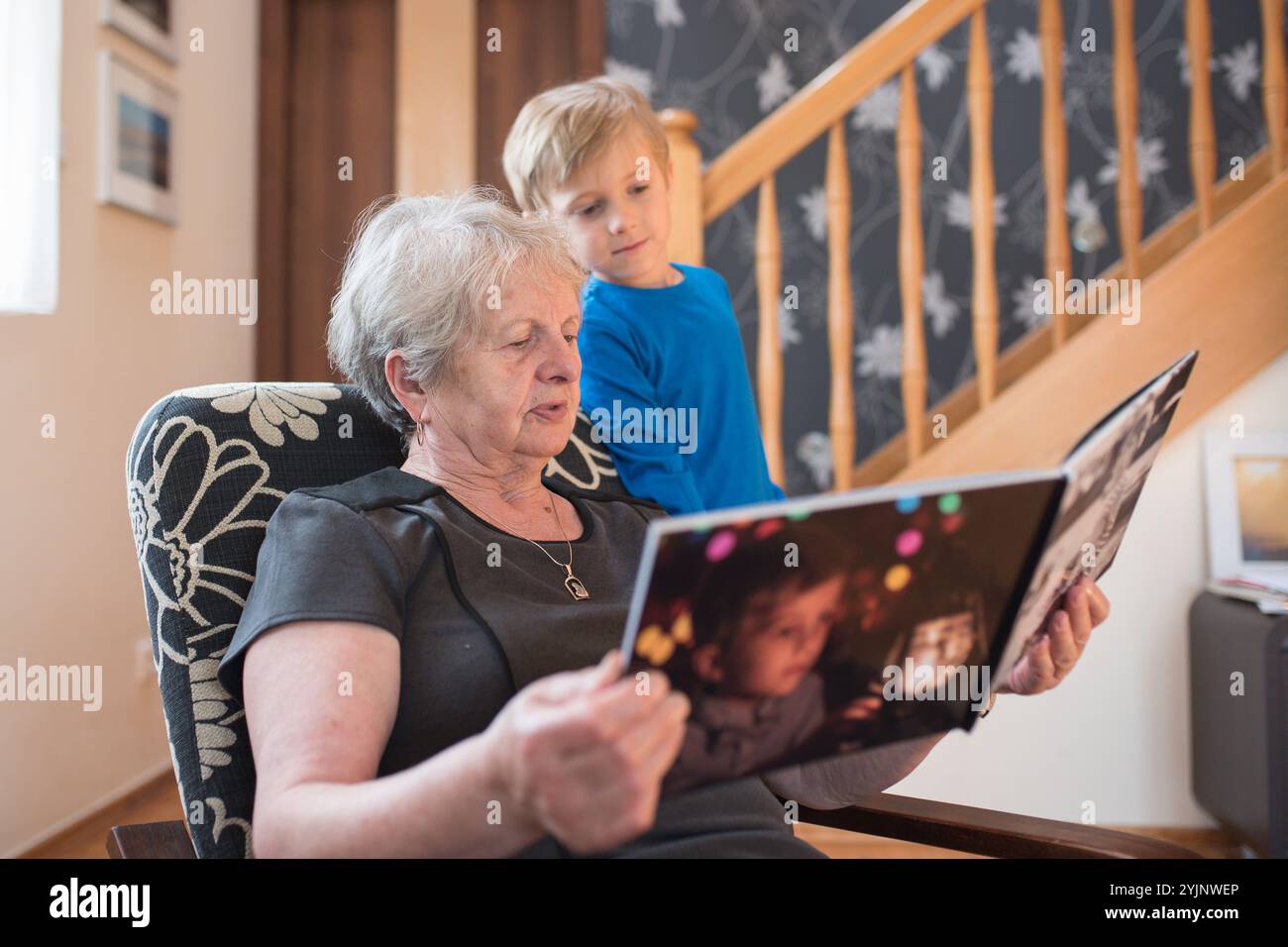 Grandmother and grandson watching photo album with the grandson ...