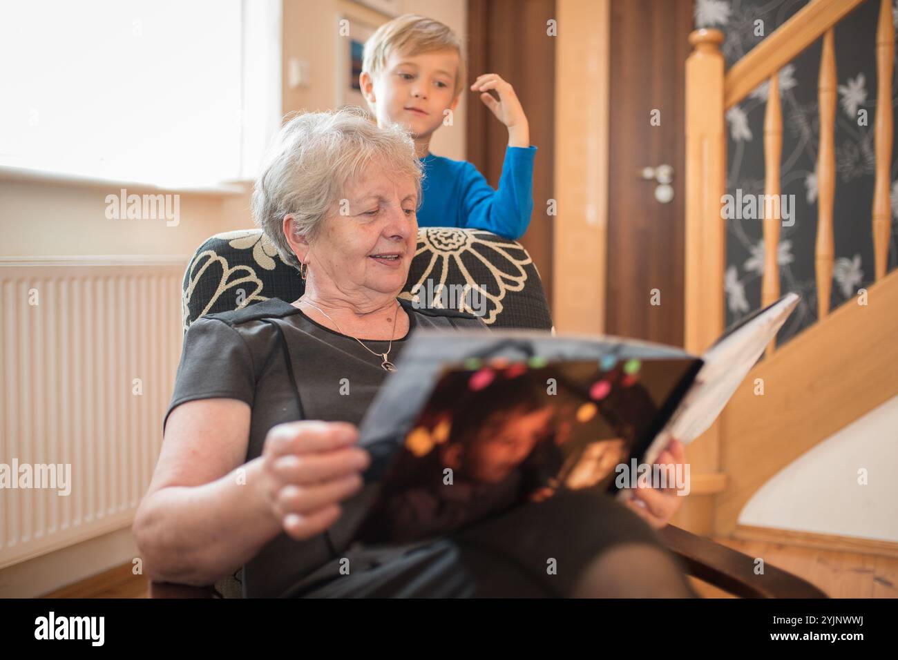 Grandmother and grandson watching photo album with the grandson ...