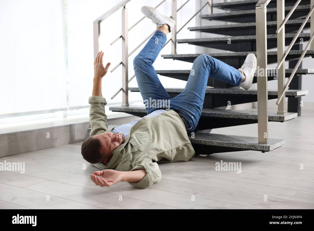 Injured man on floor in building after fall from stairs. Dangerous ...