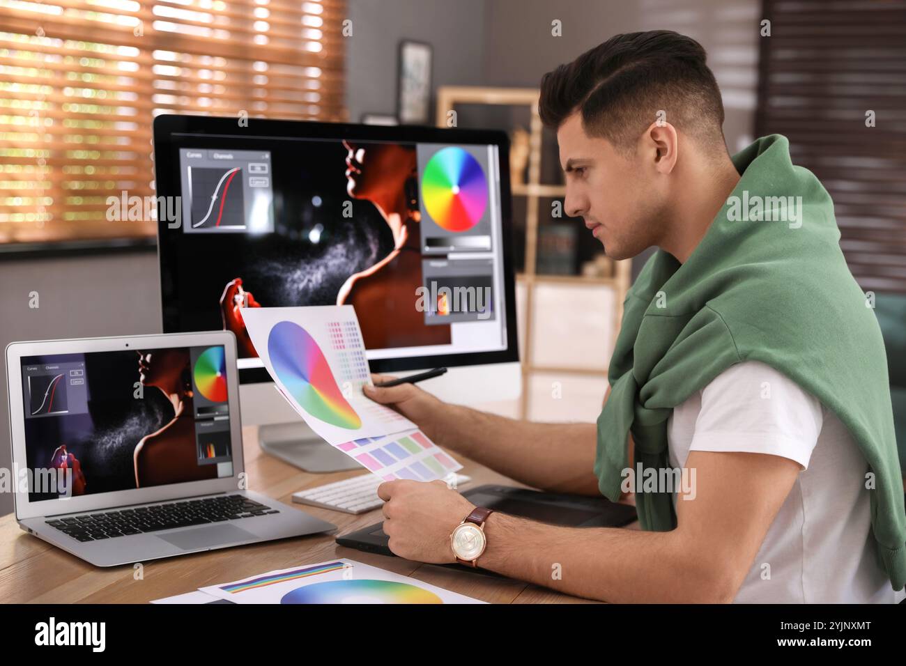 Professional retoucher with color palettes at workplace in office Stock ...