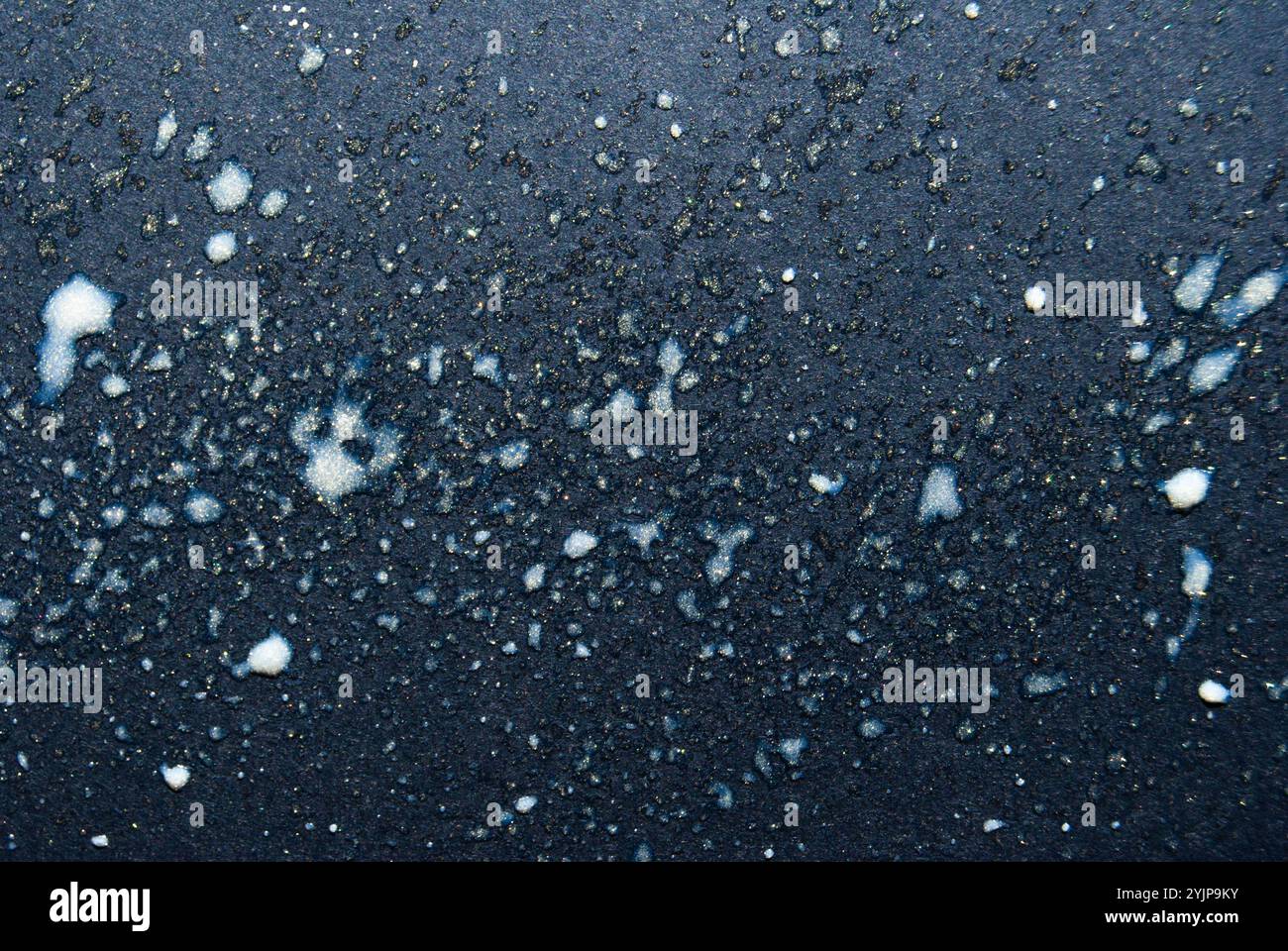 A minimalist dark background adorned with shiny white paint drops ...